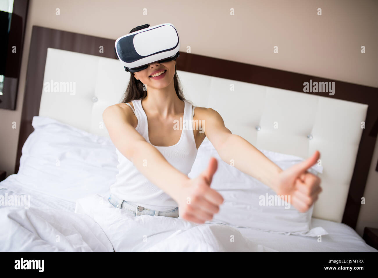 Woman playing VR at home in bedroom Stock Photo - Alamy