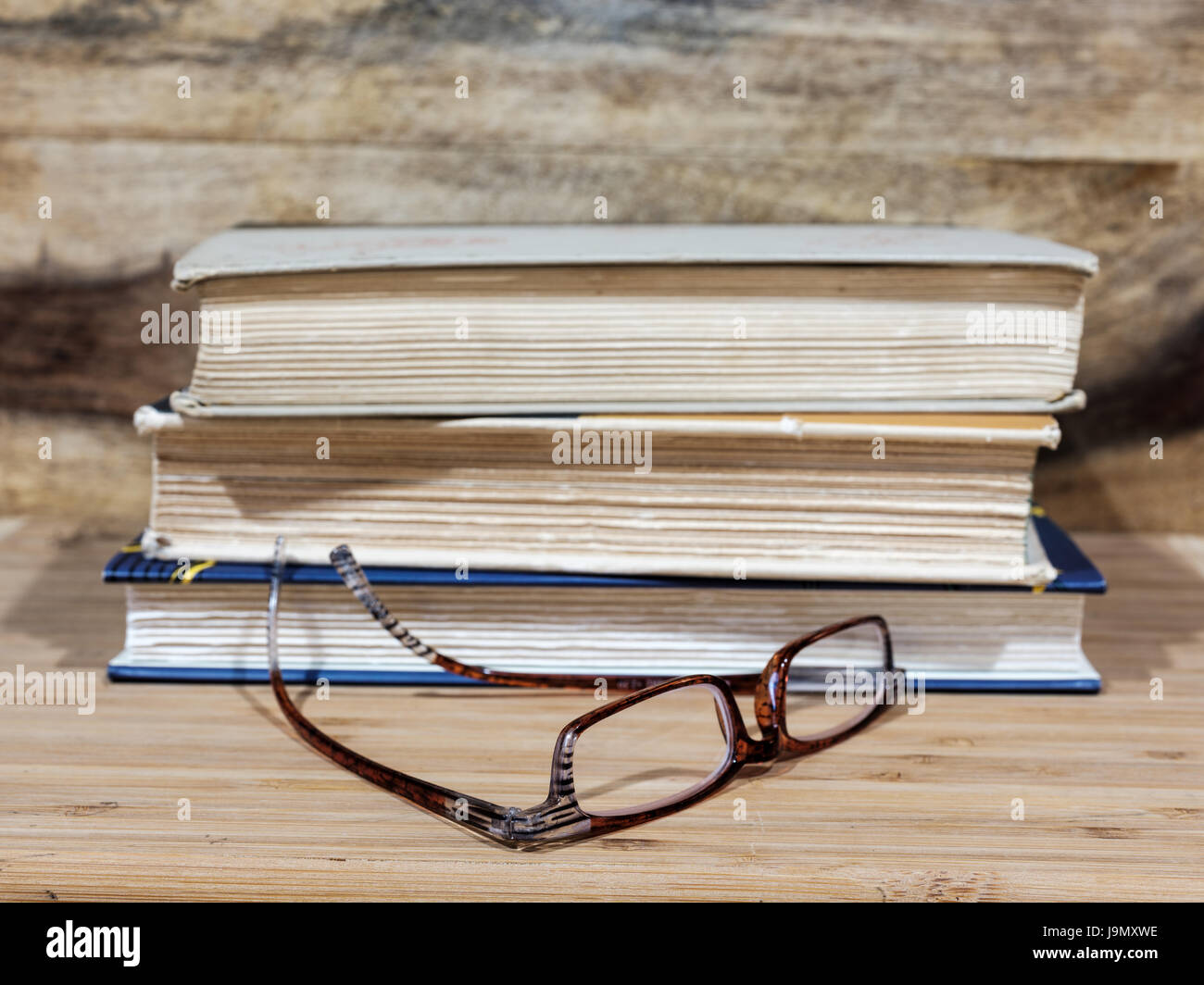 Three books with reading glasses Stock Photo - Alamy