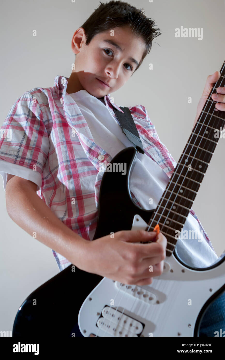Teen boy playing an electric guitar, capturing a moment of musical ...