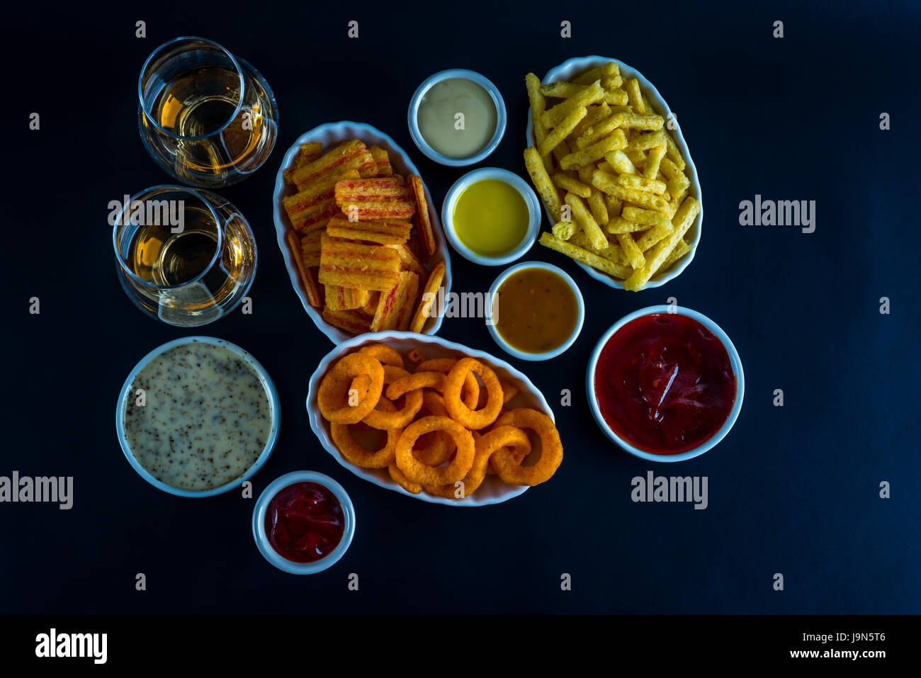 set of snacks with different dips and a single malt in a glass, crunchy ...