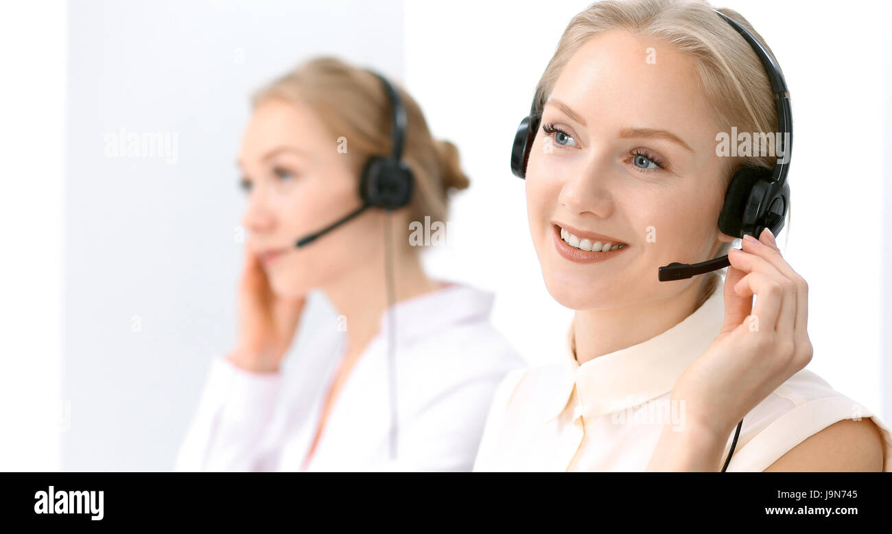 Call center. Focus on beautiful blonde woman in headset Stock Photo - Alamy