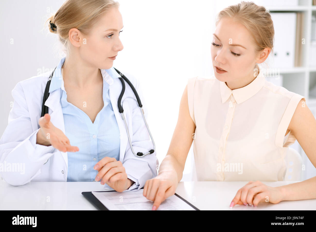 Doctor and patient sitting at the desk Stock Photo - Alamy