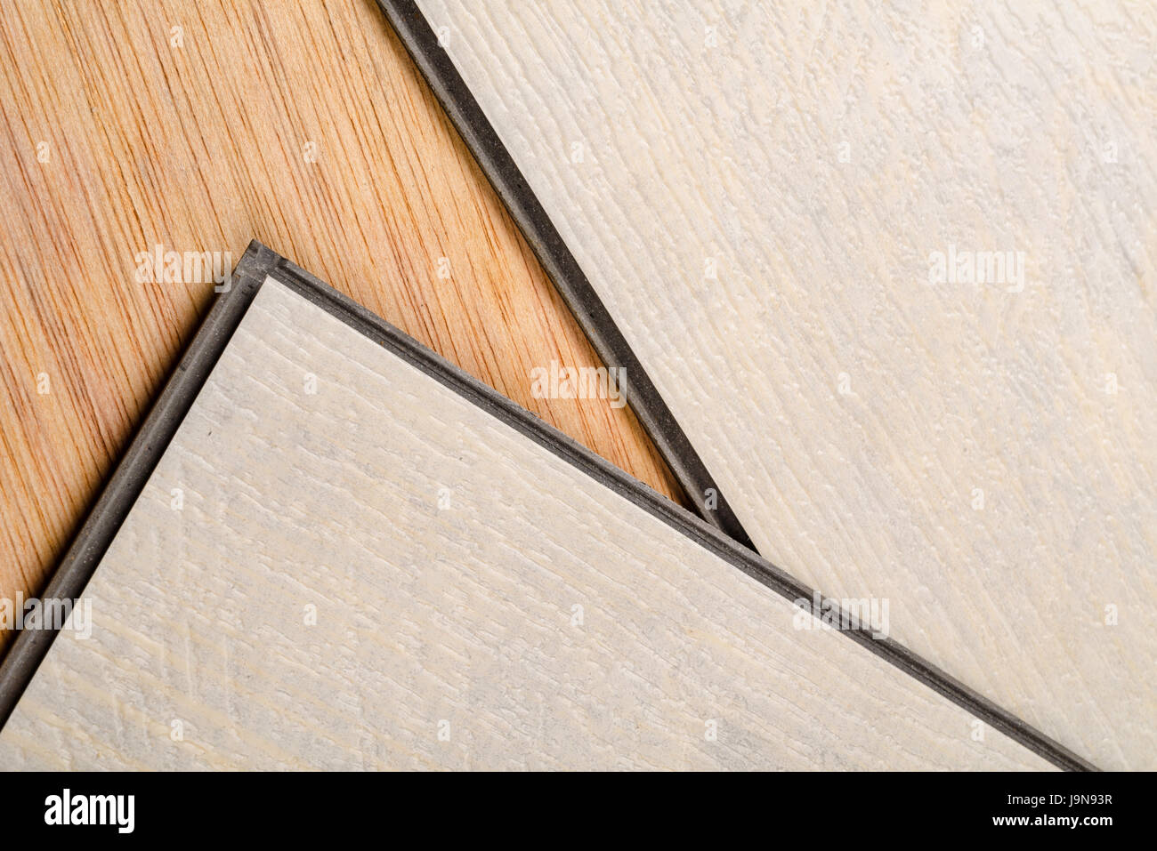 Detail take of two vinyl flooring tiles ready to be matched by their ...