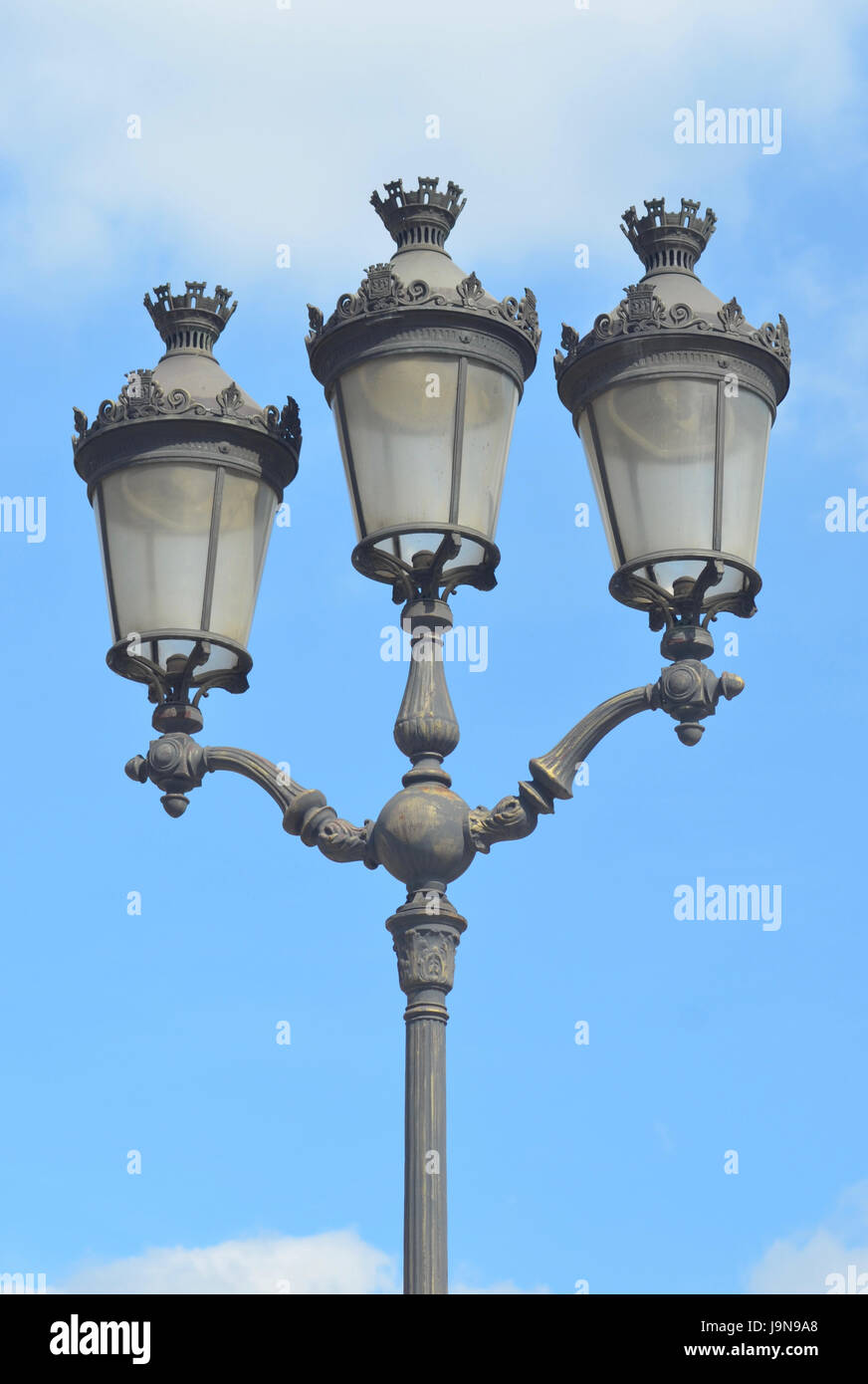 A grey Parisian lamp post against a blue sky Stock Photo - Alamy