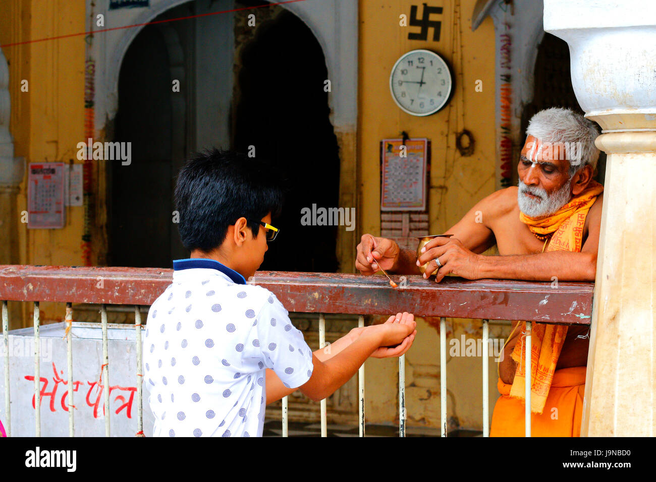 A hindu child devotee receiving prashad (blessings) from sadhu old holy ...