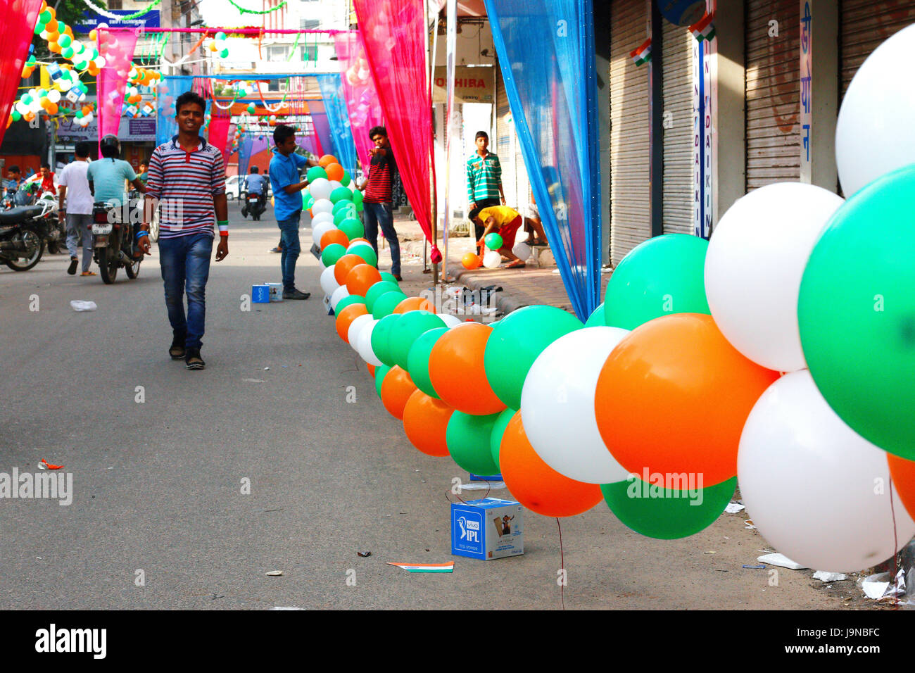 Young man preparing a string of balloons of tricolor, Indian national ...