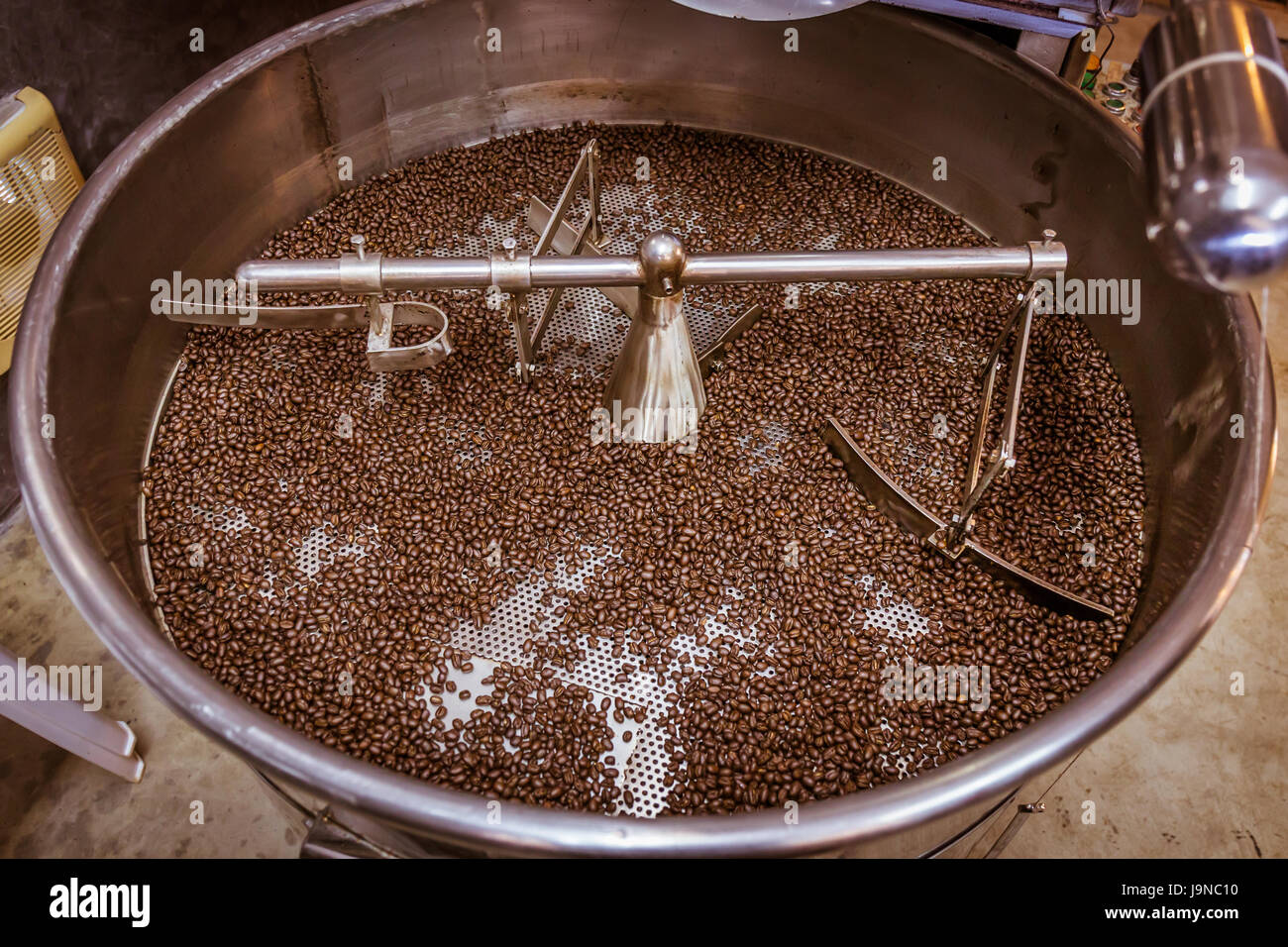 Raw coffee beans in silver roasters machine Stock Photo - Alamy