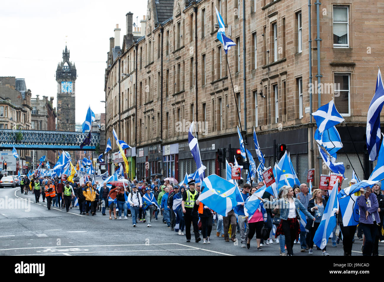 People taking part in the March for Independence through Glasgow wave ...