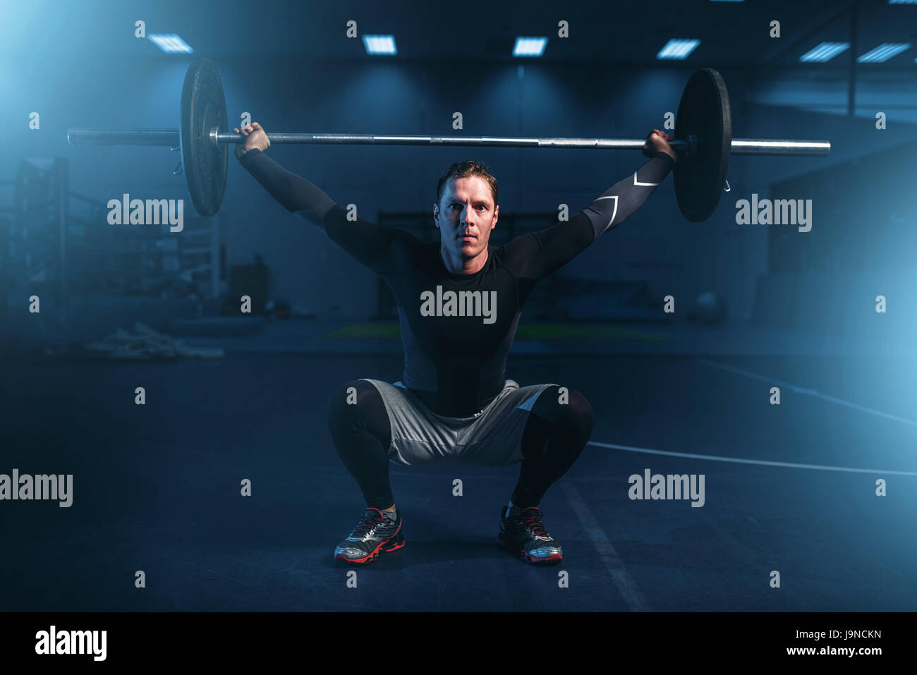 Strength athlete on training, workout with barbell in gym. Active sport ...