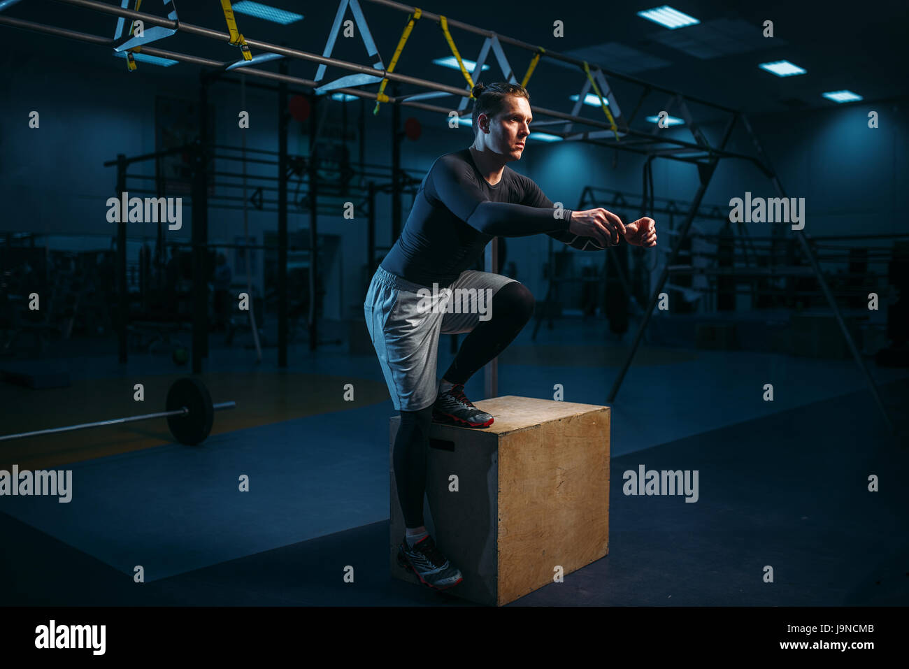 Athlete on training, endurance exercise with box in gym. Energy workout ...