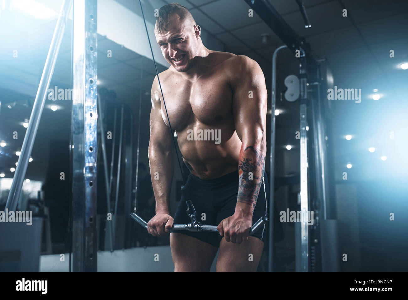 Strong athlete with muscular body lifting barbell, bodybuilding workout ...