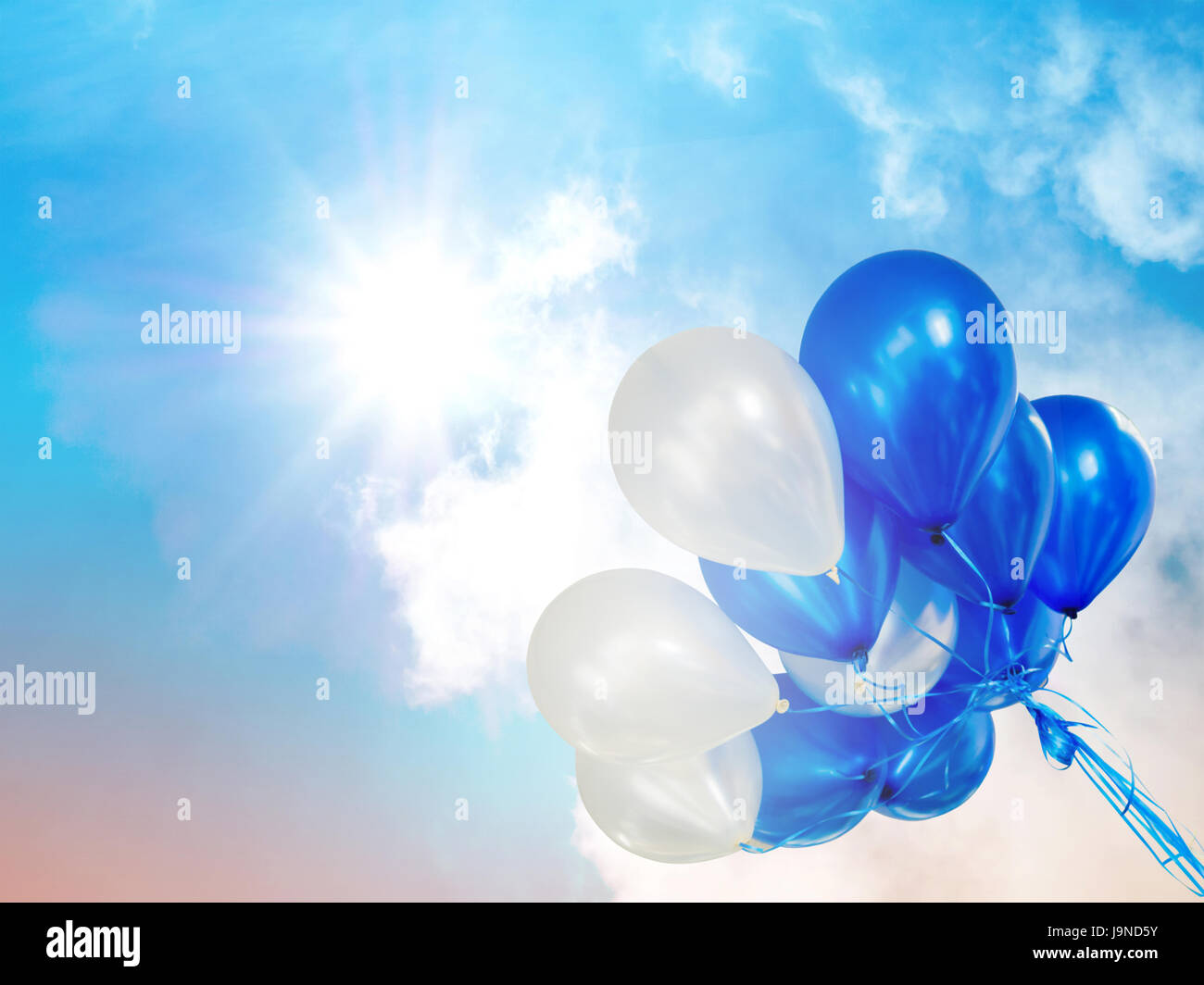 Balloons floating in pastel filtered sky with sun, happy and freedom ...