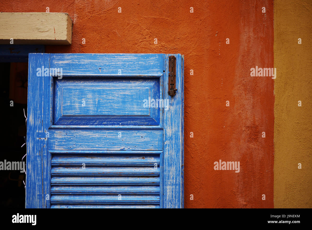 blue wood window with grunge texture on the orange and yellow wall ...