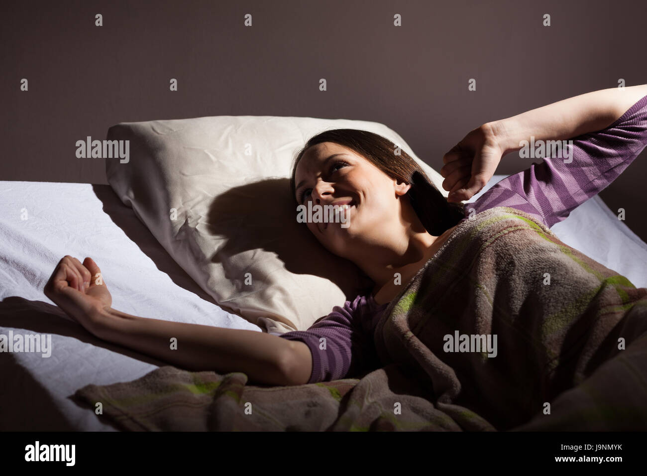 Young woman waking up early in the morning. It's time to get up for ...