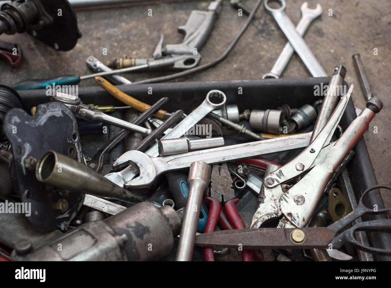 Assorted tools at the floor in workshop Stock Photo - Alamy