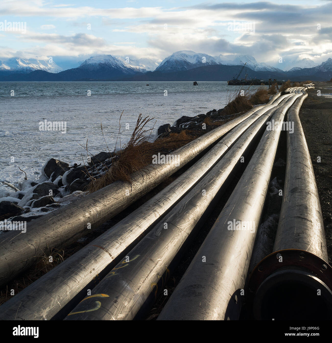 Large pipes are laid out awaiting installation along the sea shore ...