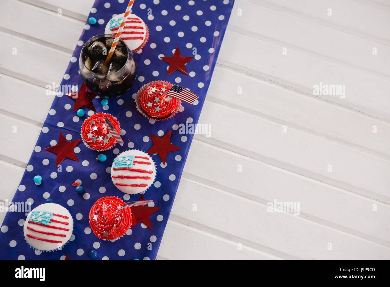 Decorated cupcakes and cold drink with 4th july theme on wooden table ...