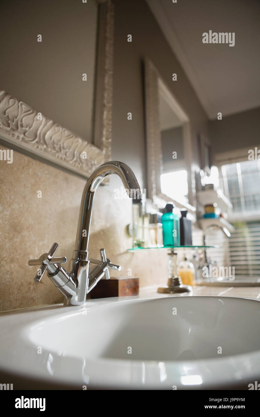 Faucet in sink in empty bathroom at home Stock Photo - Alamy
