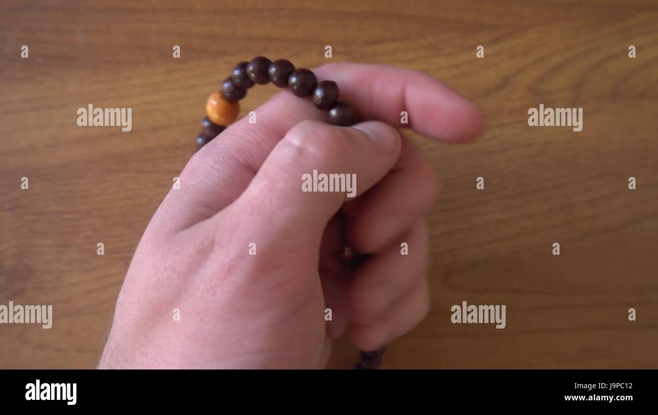 the young man's hand touches the rosary Stock Photo - Alamy