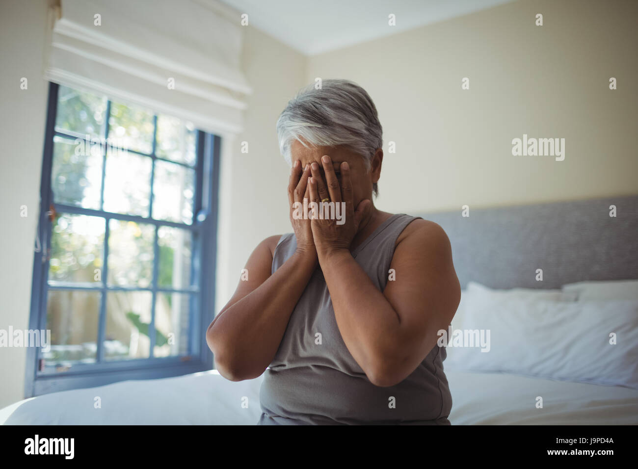 Upset senior woman covering her face at home Stock Photo - Alamy