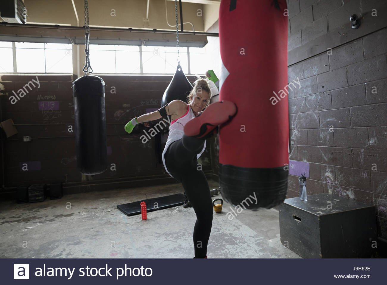 Woman kickboxing punching bag in gym Stock Photo - Alamy
