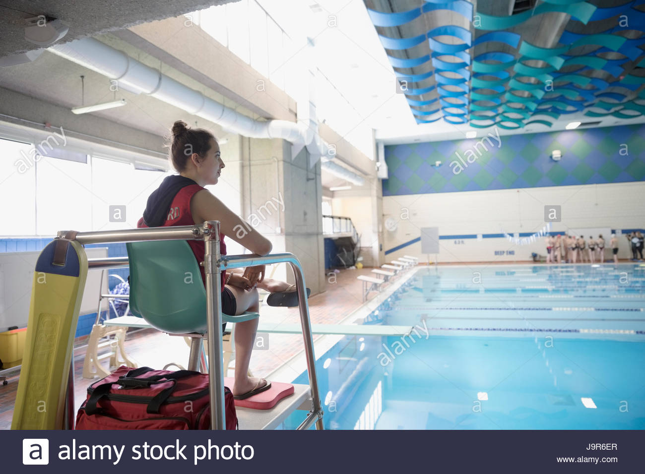 Female lifeguard sitting at lifeguard chair at swimming pool Stock ...
