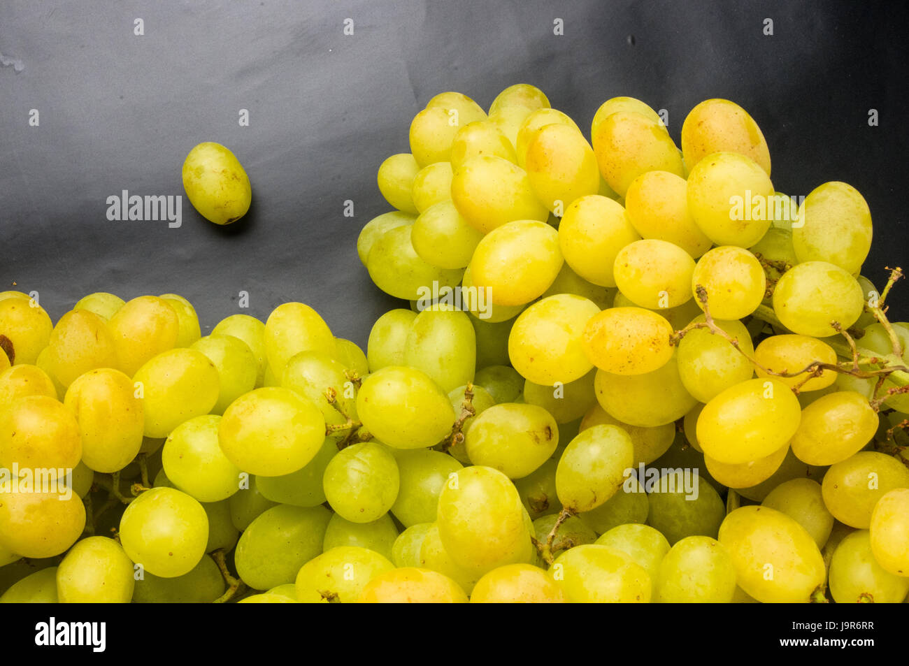 Large grapes cluster amber color on black background Stock Photo - Alamy