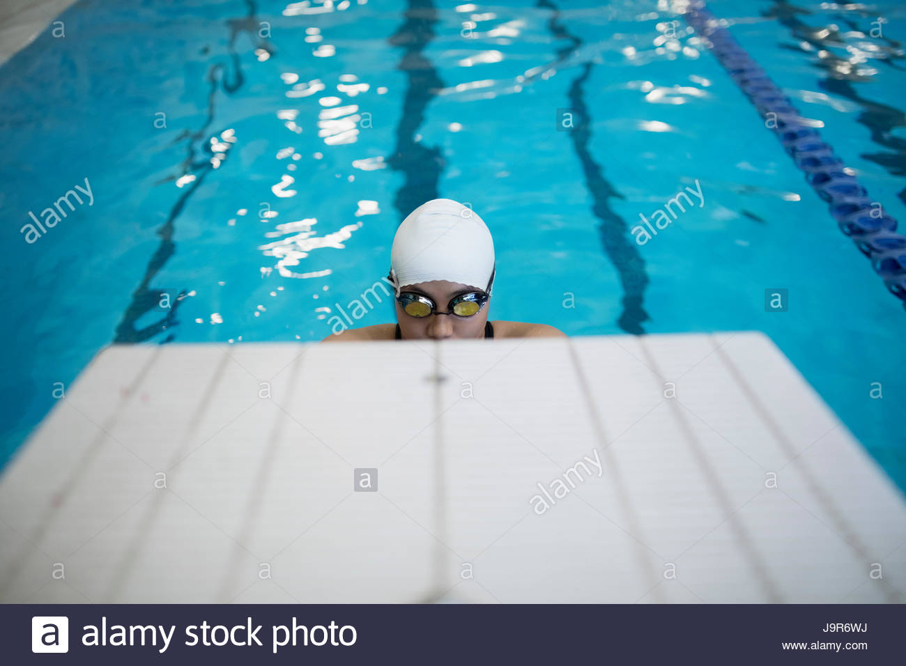Swimmer ready below starting platform in swimming pool Stock Photo - Alamy