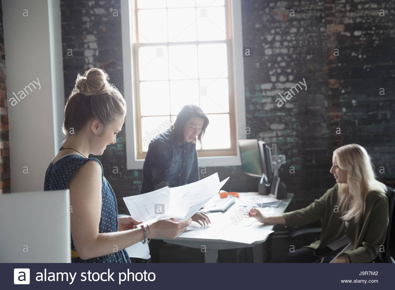 Creative business people reviewing paperwork in office Stock Photo - Alamy