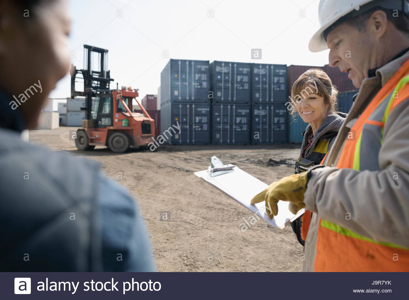 Workers with clipboard talking in industrial container yard Stock Photo ...