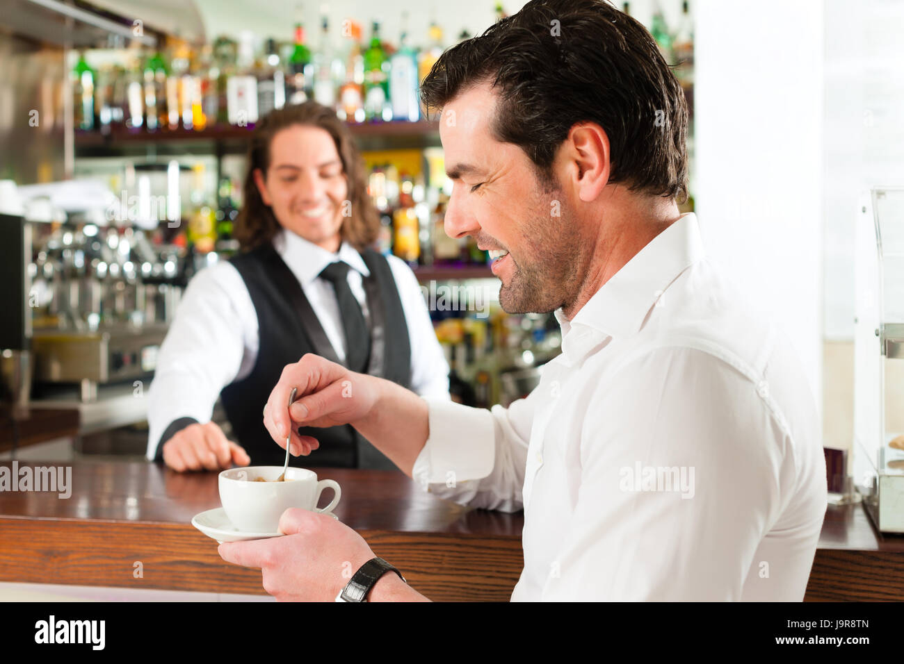 barista with guest in his cafe or coffee shop Stock Photo - Alamy