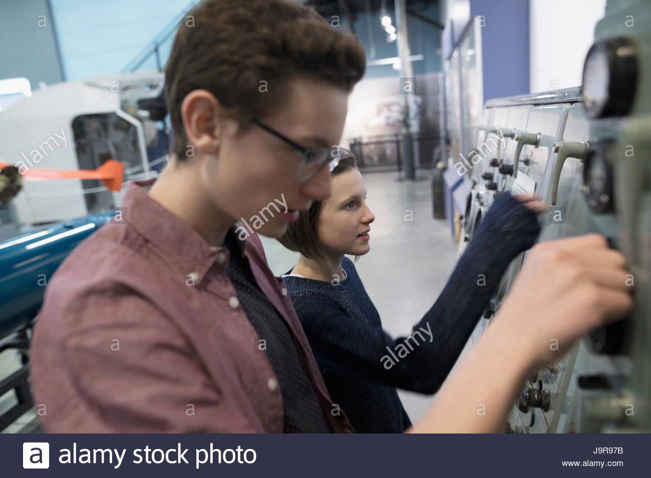 Brother and sister looking at interactive exhibit in war museum Stock ...