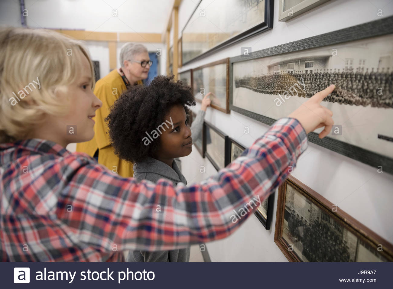 Multi-ethnic students looking at photograph exhibit on field trip at ...