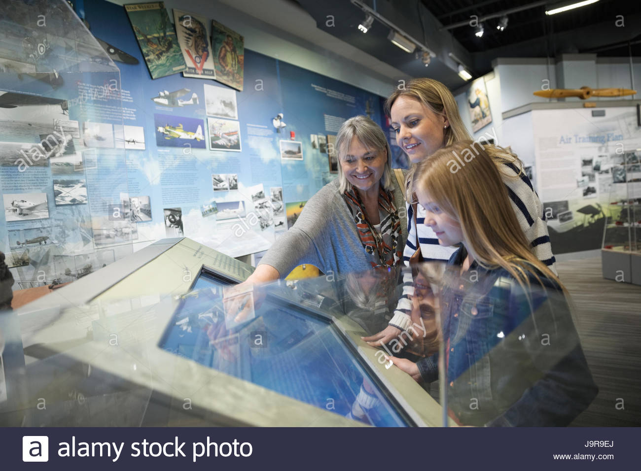 Female multi-generation family at interactive exhibit in war museum ...