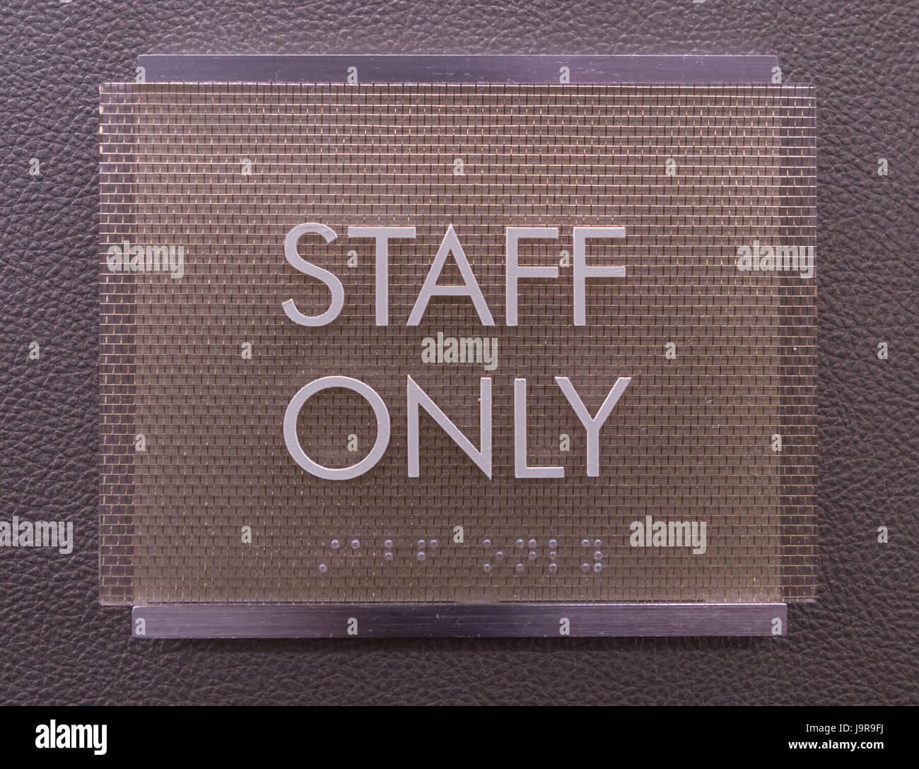 Modern Staff Only Sign with braille hangs on wall Stock Photo - Alamy