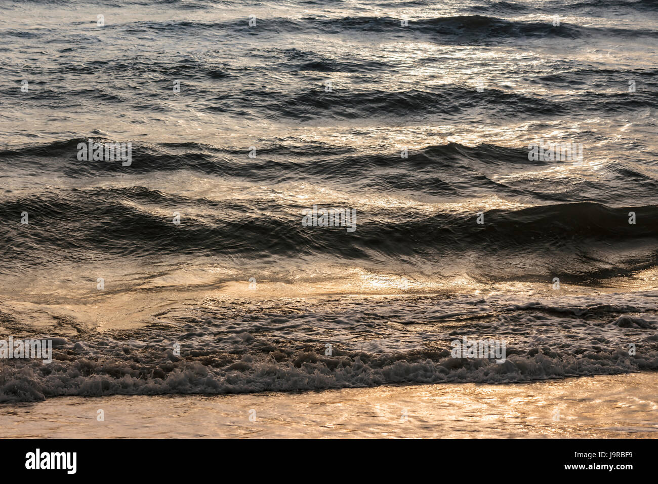 Light from the sunrise is a beautiful golden reflection of the sea ...
