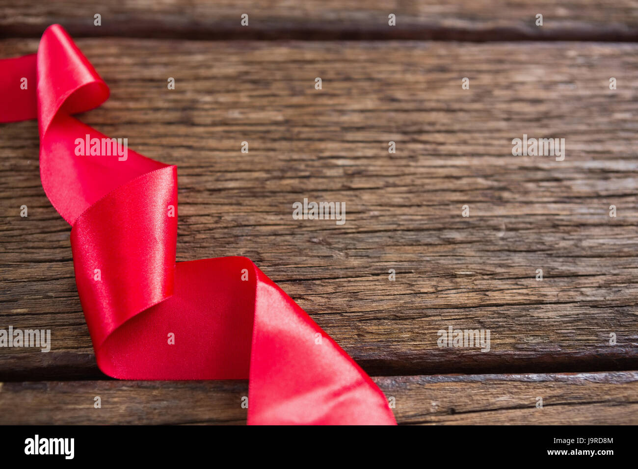 Close-up of red ribbon on wooden table Stock Photo - Alamy