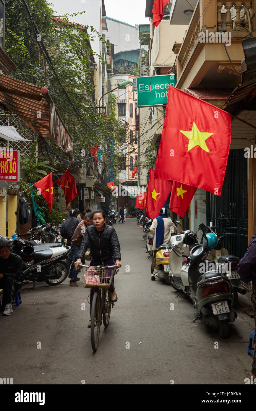 Busy alley and Vietnamese flags in busy Old Quarter, Hanoi, Vietnam ...