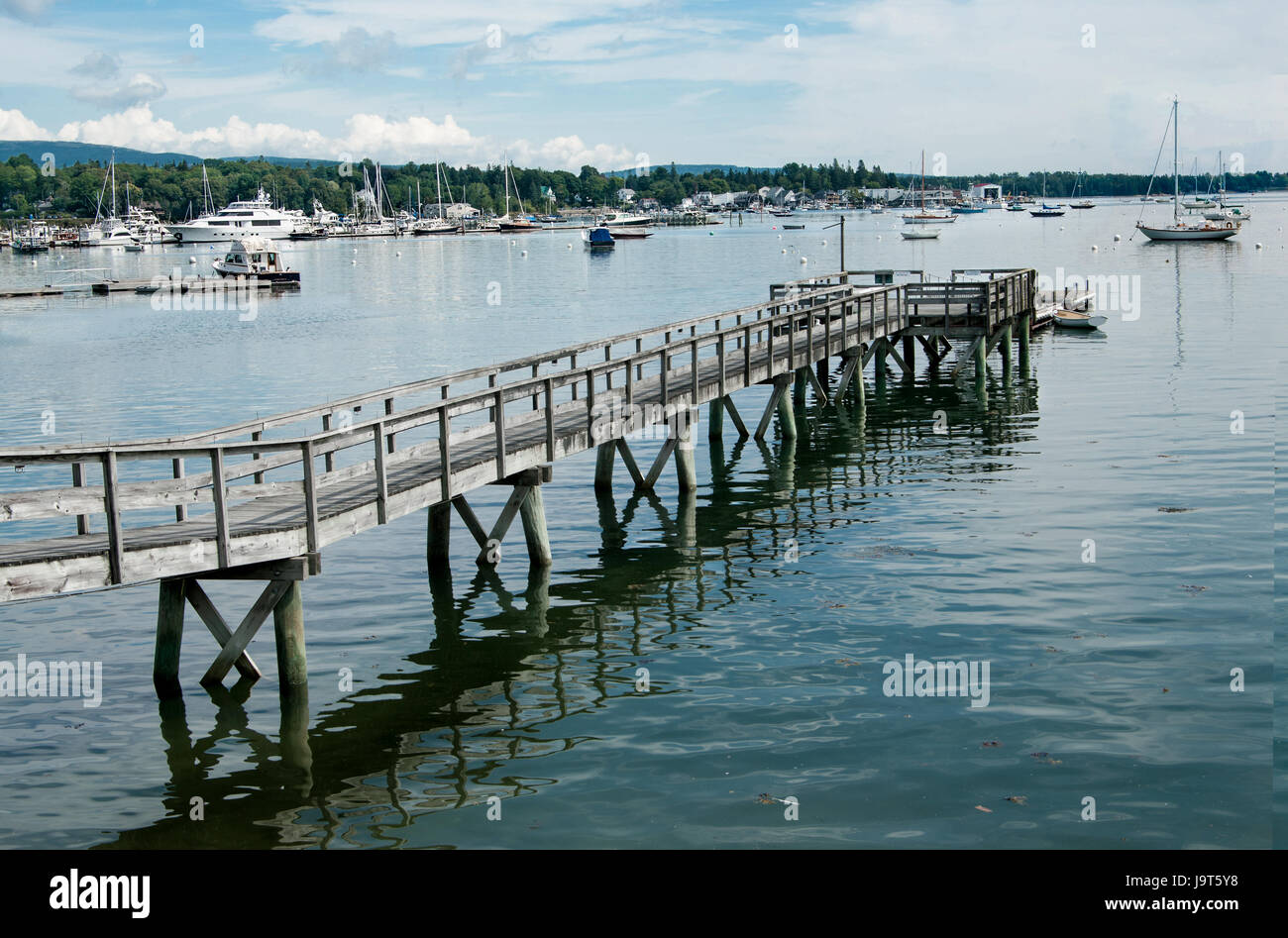 Long Pier: A wooden walkway extends far across the shallow end of a bay ...