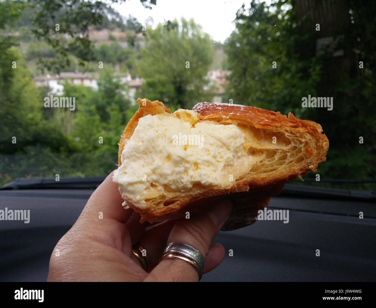 Woman holding delicious delicacy of the brioche with custard. Cake to ...