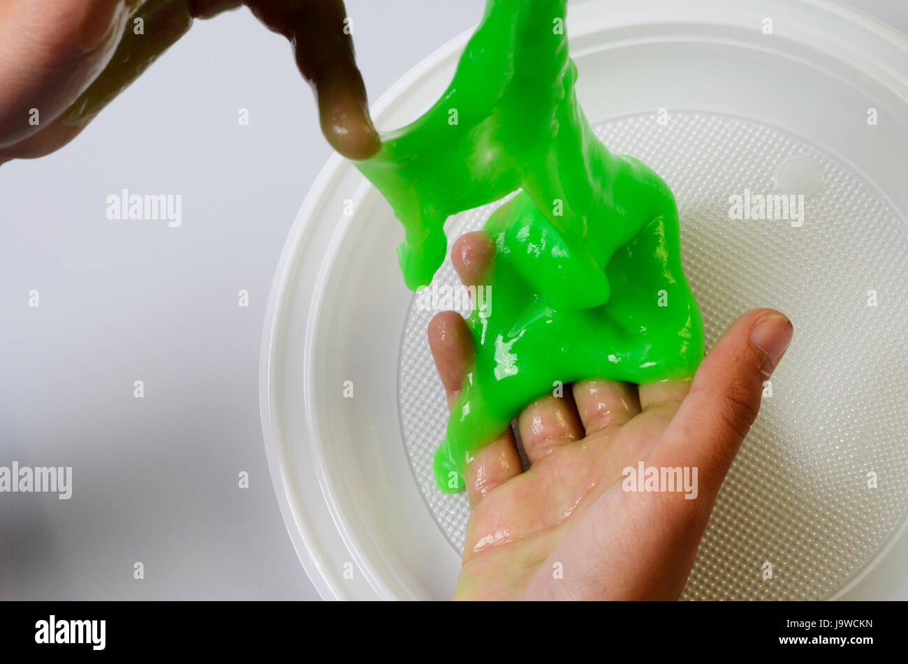 Slime, green pate elastic and viscous on child's hand Stock Photo - Alamy