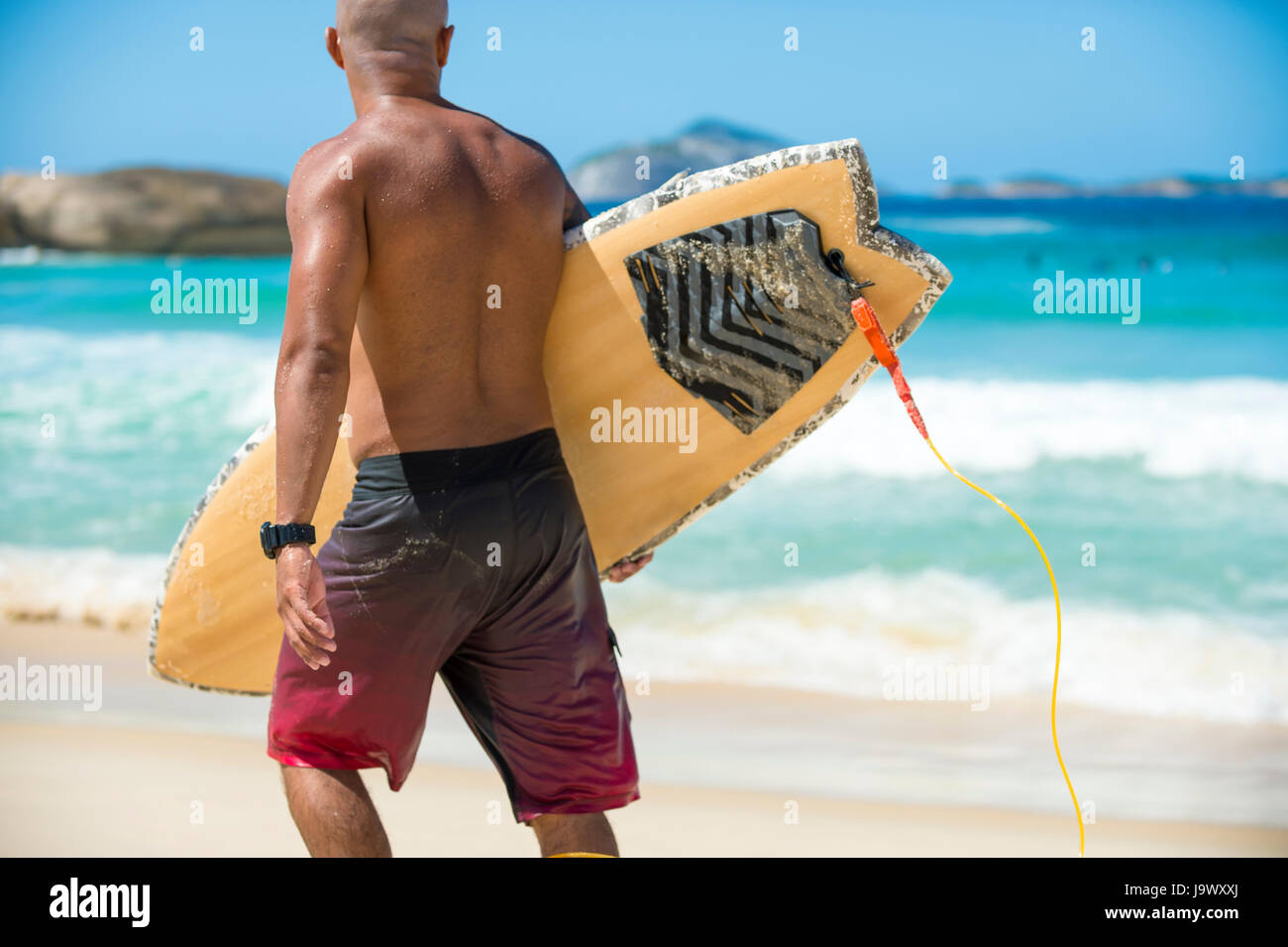 RIO DE JANEIRO - FEBRUARY 9, 2017: Brazilian surfer walking with his ...