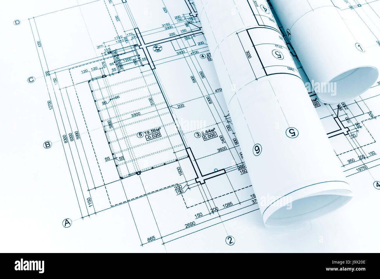 house plan drawing with rolled blueprints on desk. architectural ...