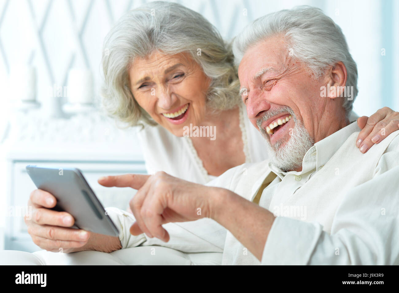 Happy elderly couple using a tablet computer Stock Photo - Alamy