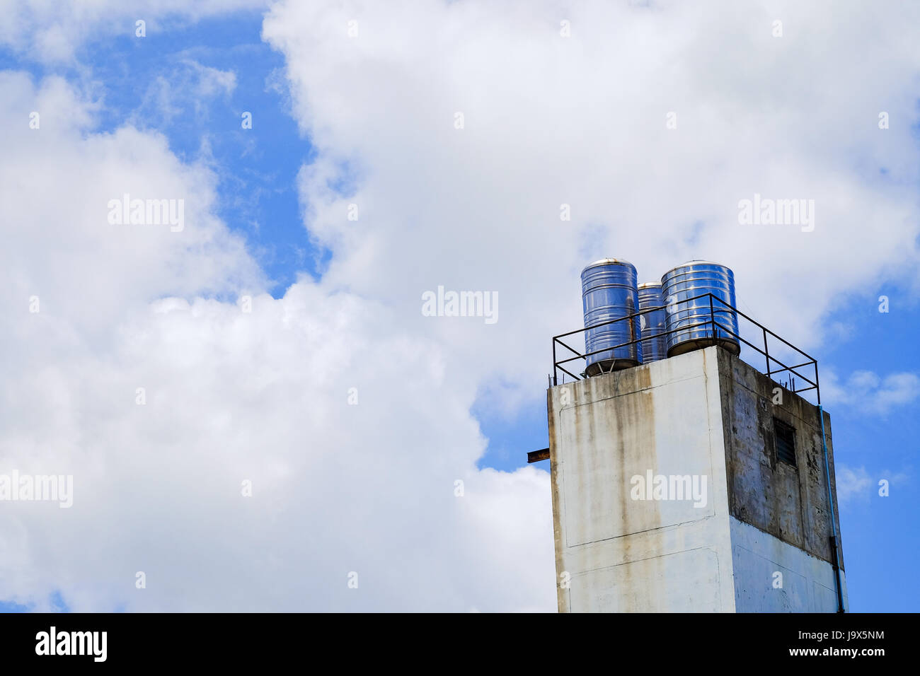 Bright blue sky with cloud and water tanks Stock Photo - Alamy