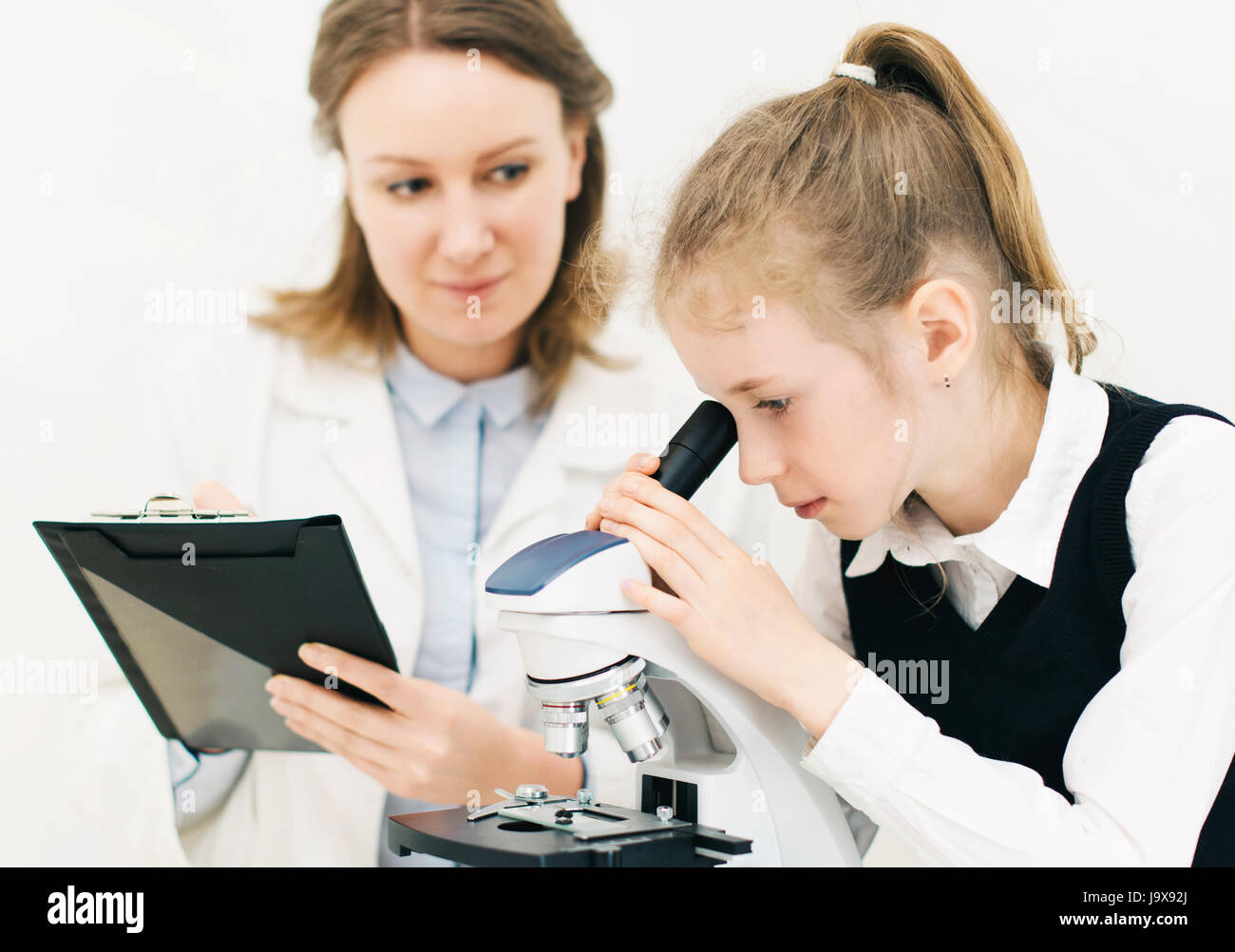 Woman and little girl using microscope in laboratory Stock Photo - Alamy