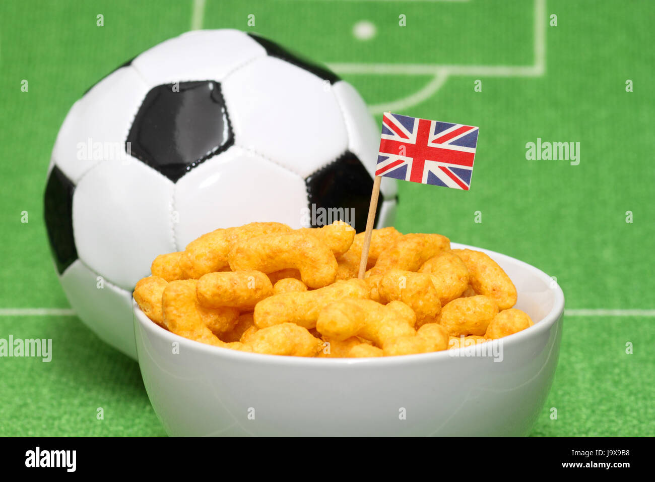 Soccer ball with crispy snacks in a bowl on green background Stock ...