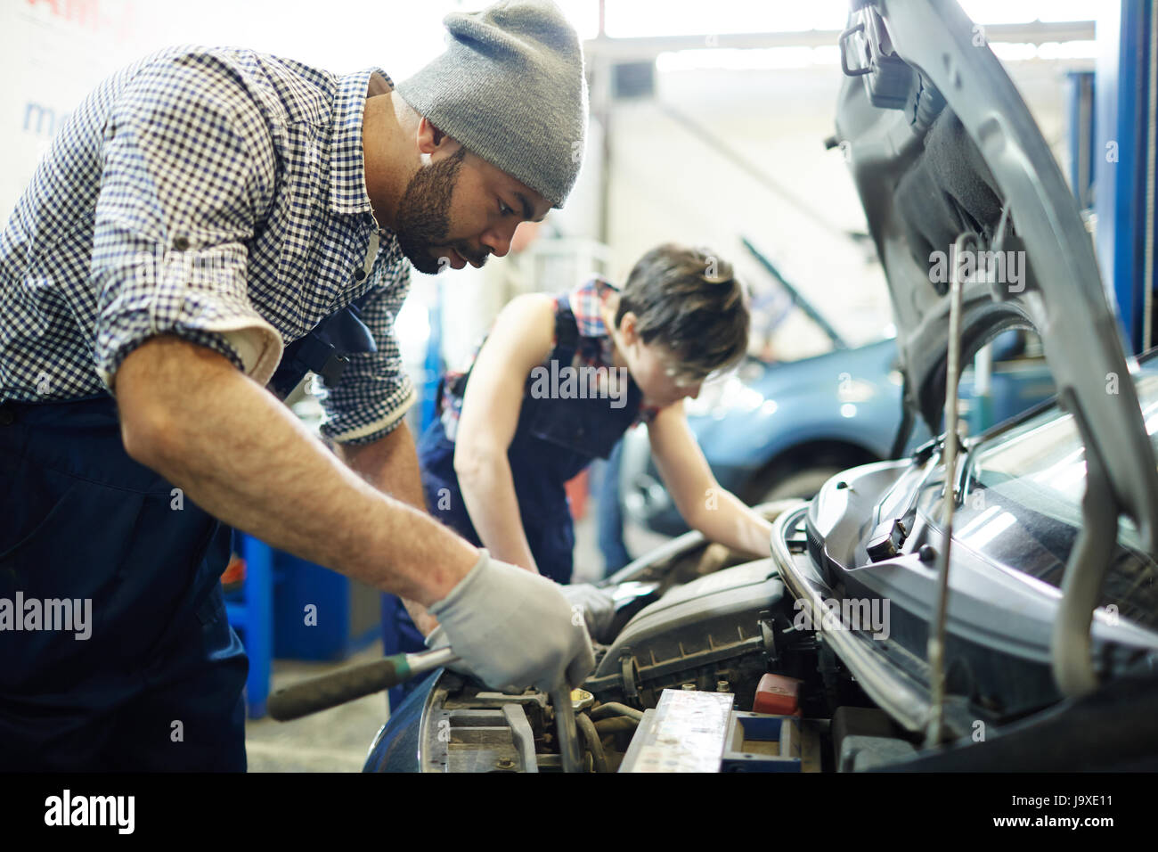 Car service technician repairing engine Stock Photo - Alamy