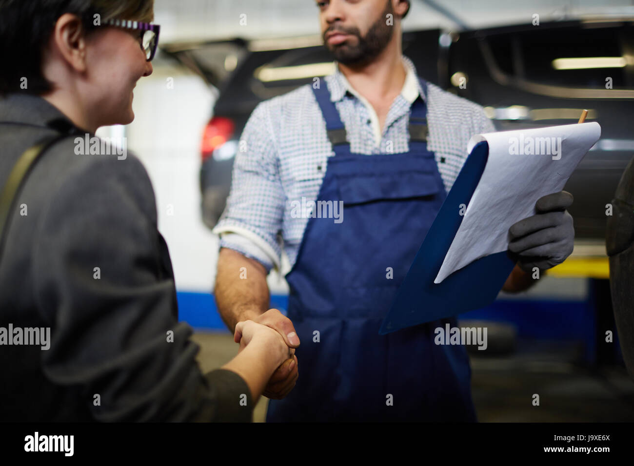 Young client handshaking with car service professional Stock Photo - Alamy