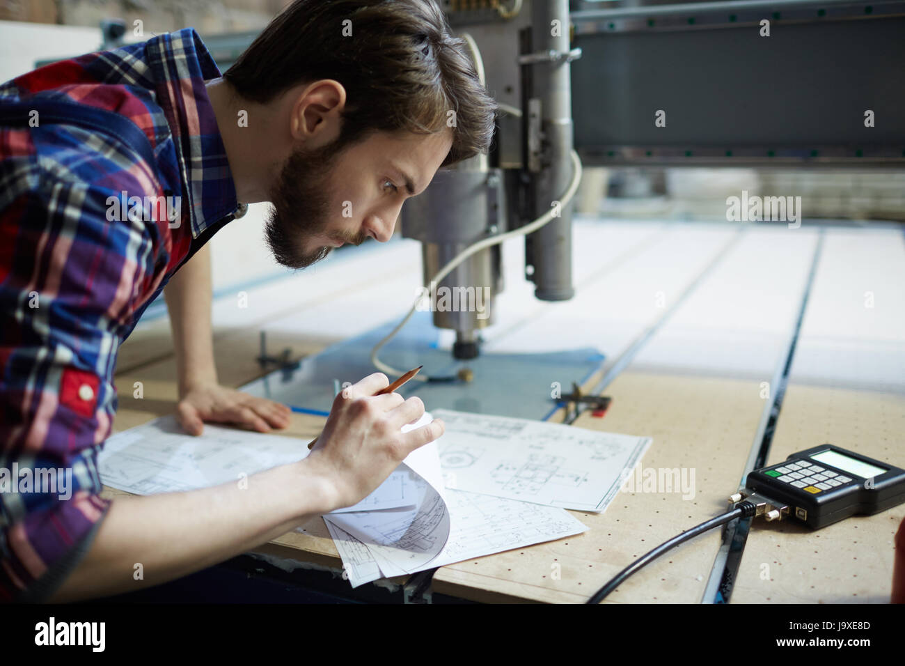 Serious engineer looking through papers with technical sketches Stock ...